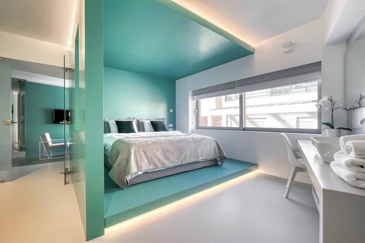Quarto moderno com uma cama, uma escrivaninha e uma janela.