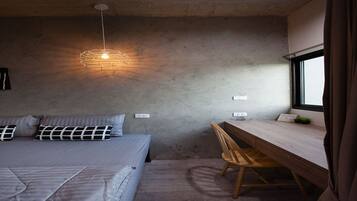 Um quarto com cama, escrivaninha e janela.