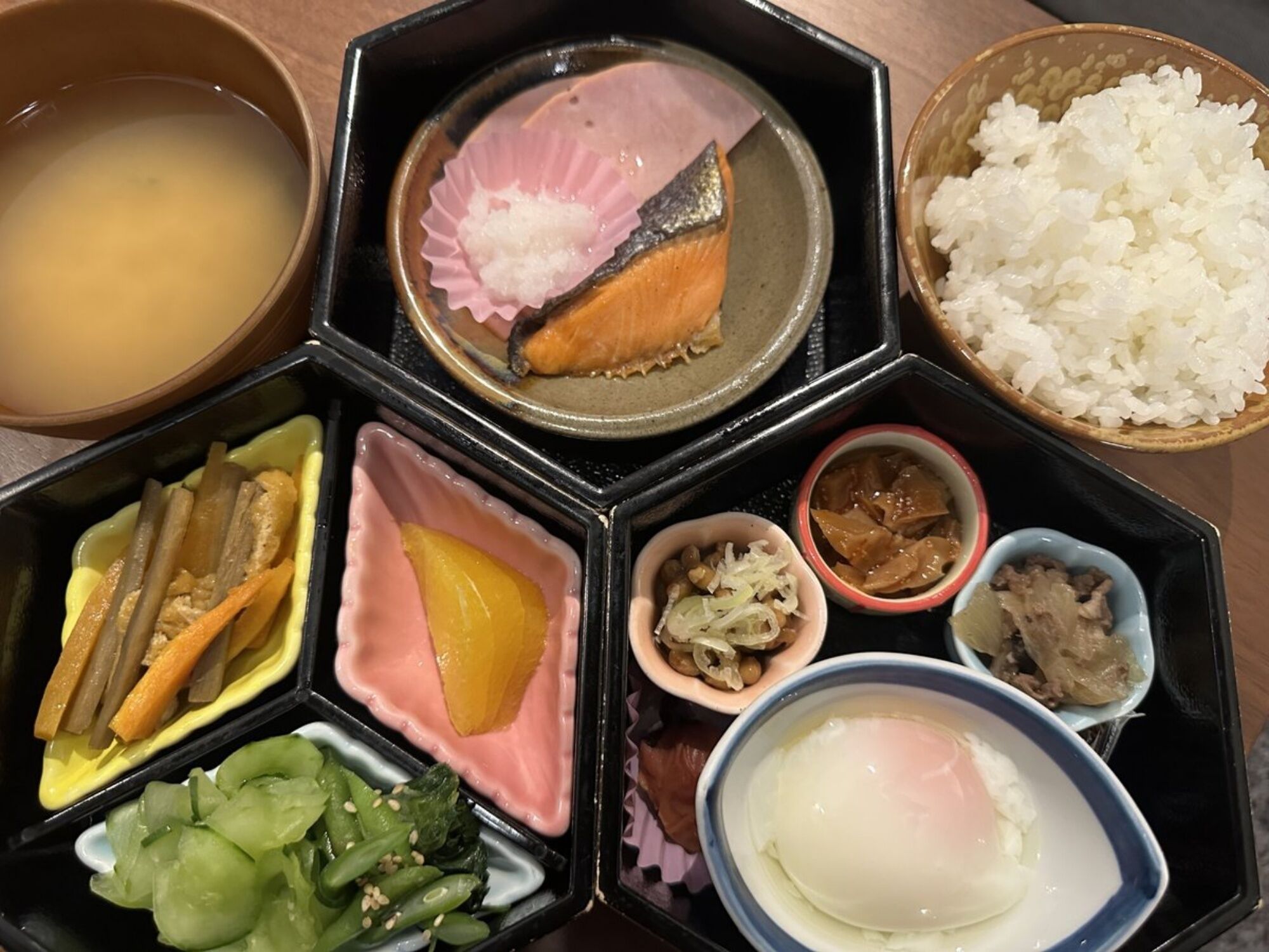 Uma tradicional marmita japonesa com diversos compartimentos contendo arroz, peixe, legumes e itens em conserva.