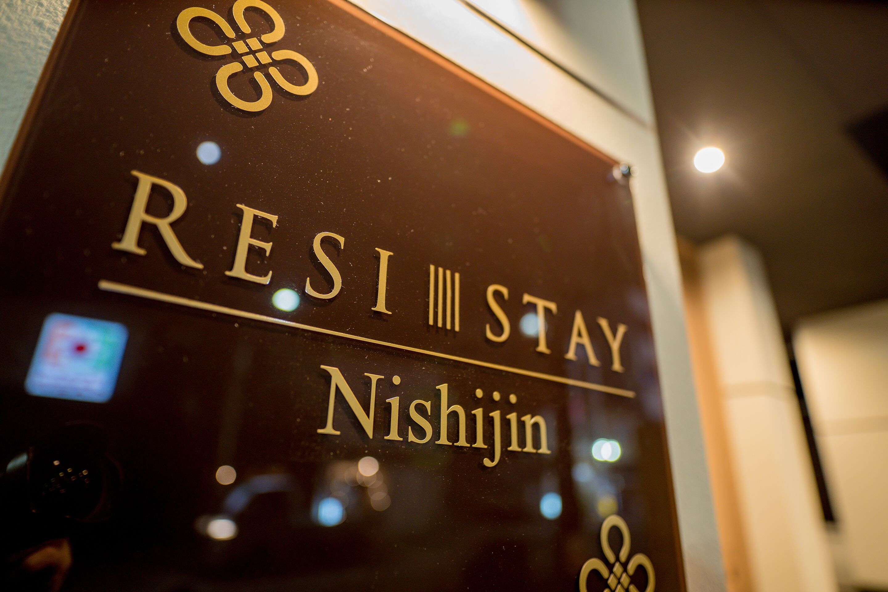 Um letreiro com o texto 'RESI STAY Nishijin'.