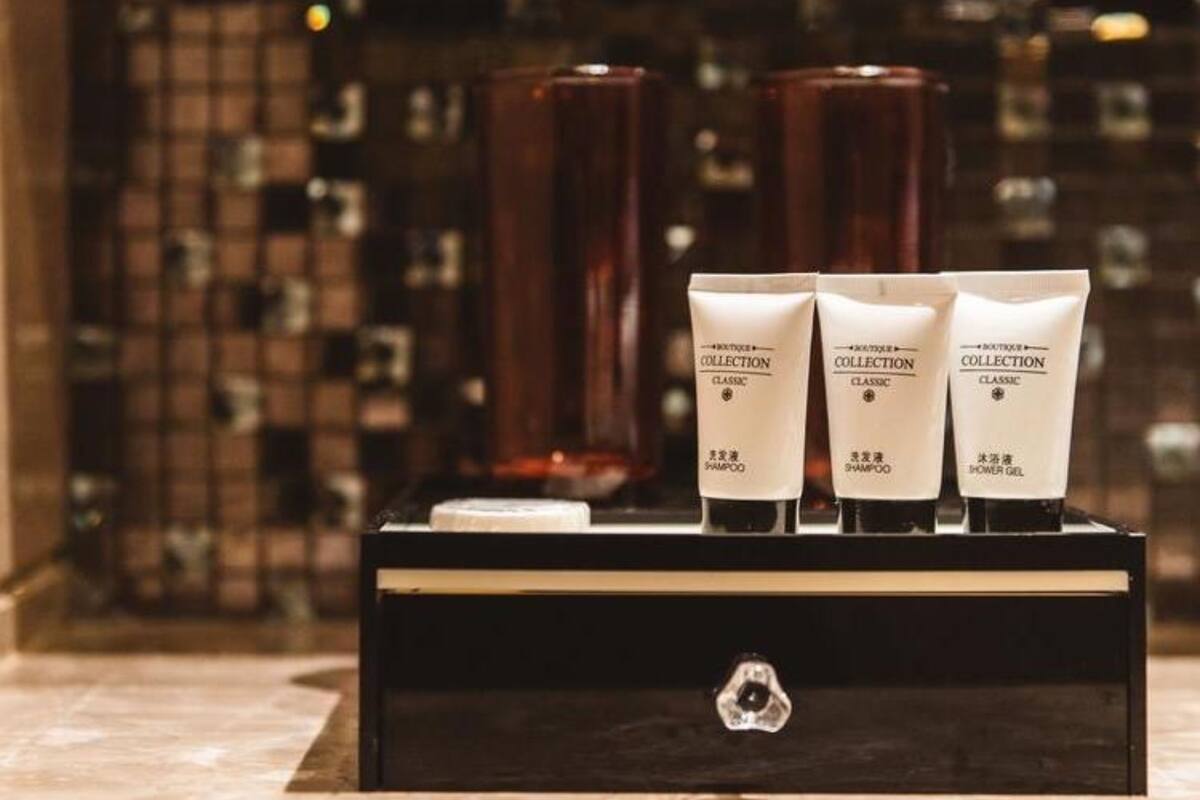 Um lavatório de banheiro com um porta-objetos preto que acomoda três produtos de higiene pessoal rotulados 'Classic Collection'.