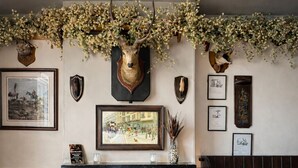 Um quarto aconchegante com lareira, quadros decorativos e chifres de veado.