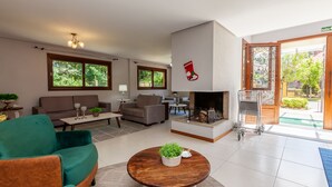 Uma sala de estar moderna com lareira, um sofá verde-água e uma mesa de centro com uma planta.