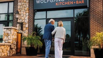 Um edifício com uma placa que diz "Wolfgang Puck Kitchen+Bar".