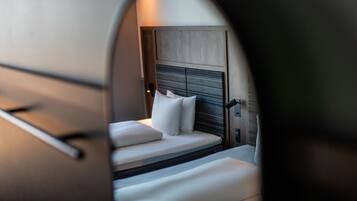 Quarto moderno e compacto com cama, almofadas e cabeceira.