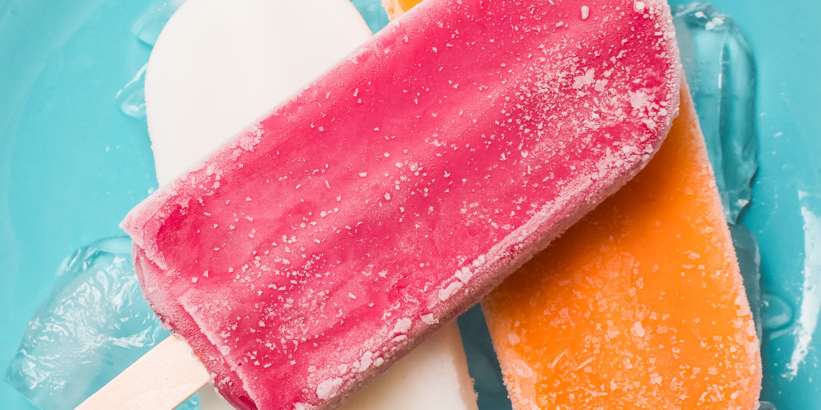 Um close-up de duas barras de gelado, com uma de cor branca e laranja ao fundo.
