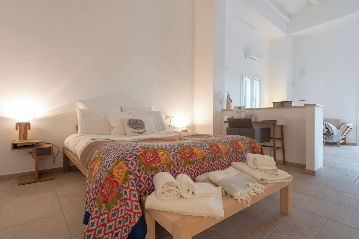 Quarto com cama, escrivaninha e cadeira.