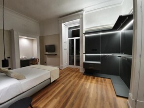 Um quarto com cama, escrivaninha, televisão e closet espaçoso.