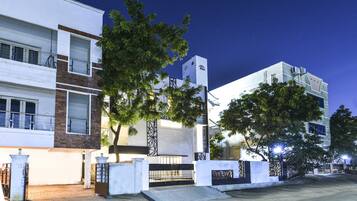 Um edifício moderno com fachada de tijolo e branco, grandes janelas e portão fechado.