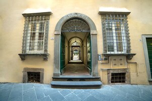 Entrada de um edifício com uma escadaria de pedra que leva a uma porta com o número 78.