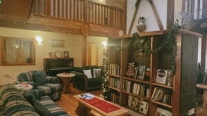 Uma sala de estar acolhedora com um sofá listrado, uma mesa de centro de madeira e uma estante de livros.
