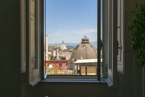 Vista através de uma janela aberta de um horizonte urbano com uma estrutura em cúpula imponente.