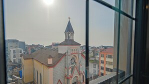 Uma igreja com uma cruz no topo, um relógio e uma janela com uma cruz.