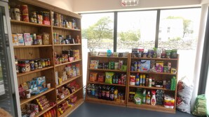 Um supermercado com prateleiras repletas de diversos produtos alimentares e artigos domésticos.
