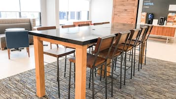 Uma sala de conferências com uma mesa grande, cadeiras e um espaço para café.