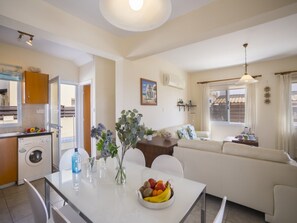 Um espaço compacto para viver com cozinha, área de refeições e sofá.