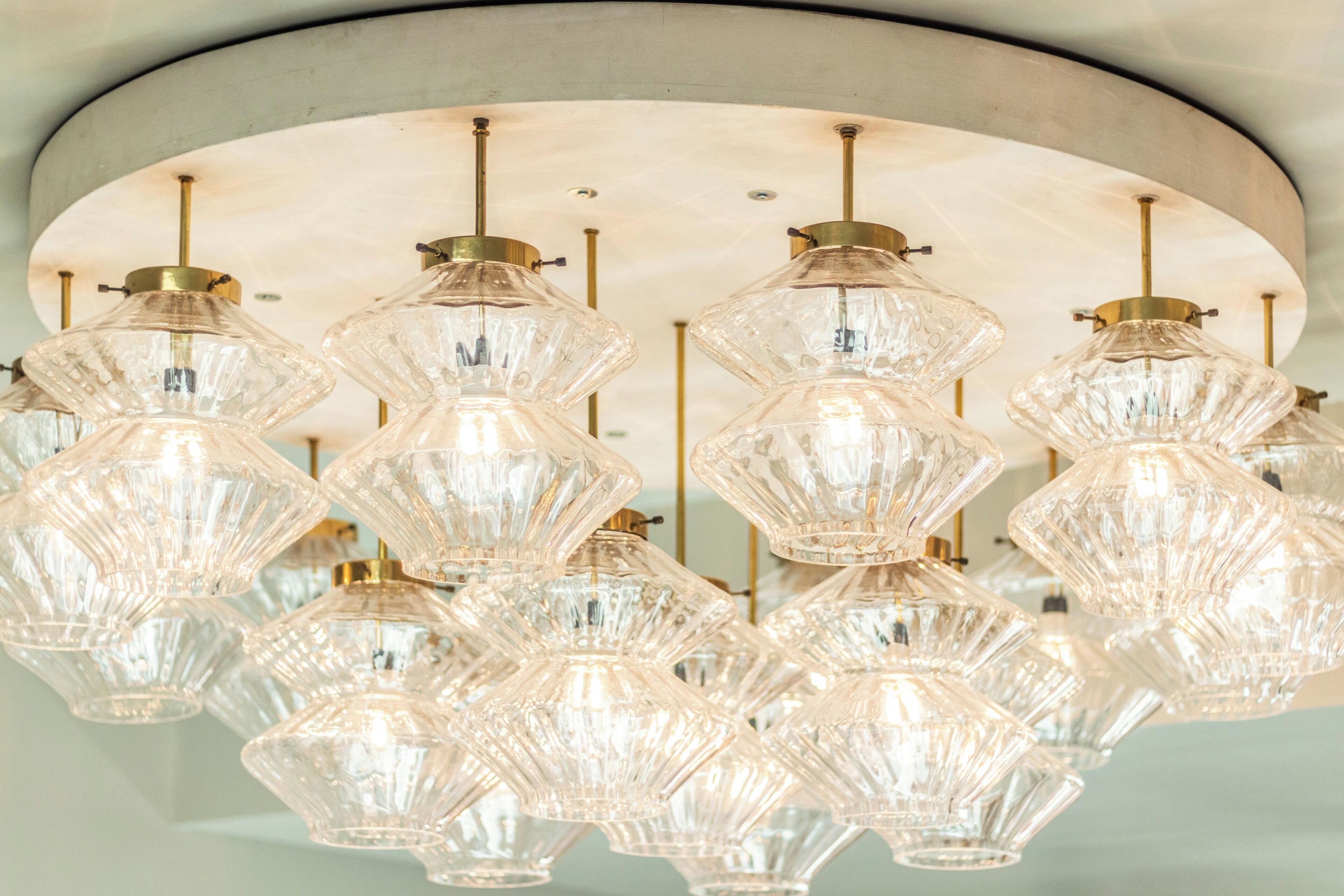 Um candelabro com múltiplas lâmpadas de vidro e detalhes em latão.