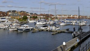 Uma marina com vários barcos atracados, rodeada por edifícios residenciais.