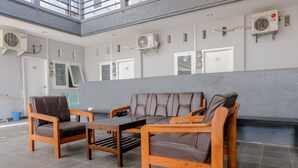 Um lobby moderno com área de estar, móveis de madeira e piso revestido.