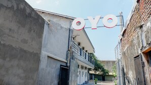 A building with a sign reading "OYO" and a balcony.