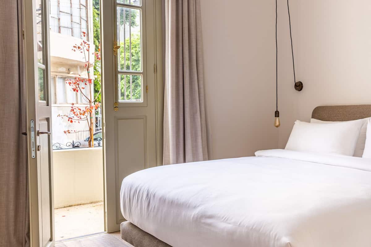 Quarto com cama, porta e vista para o exterior.