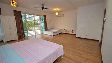 Quarto amplo com uma cama grande, uma cama menor, um guarda-roupa e um ventilador de teto.