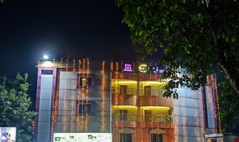 Um edifício com várias varandas e um letreiro de neon indicando um bar.