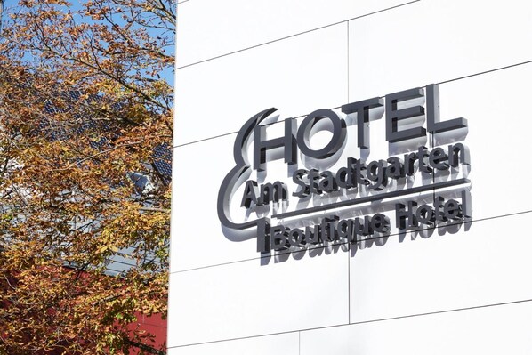 Placa de hotel com o nome 'HOTEL An Stadtgarten Boutique Hotel' em um edifício branco.