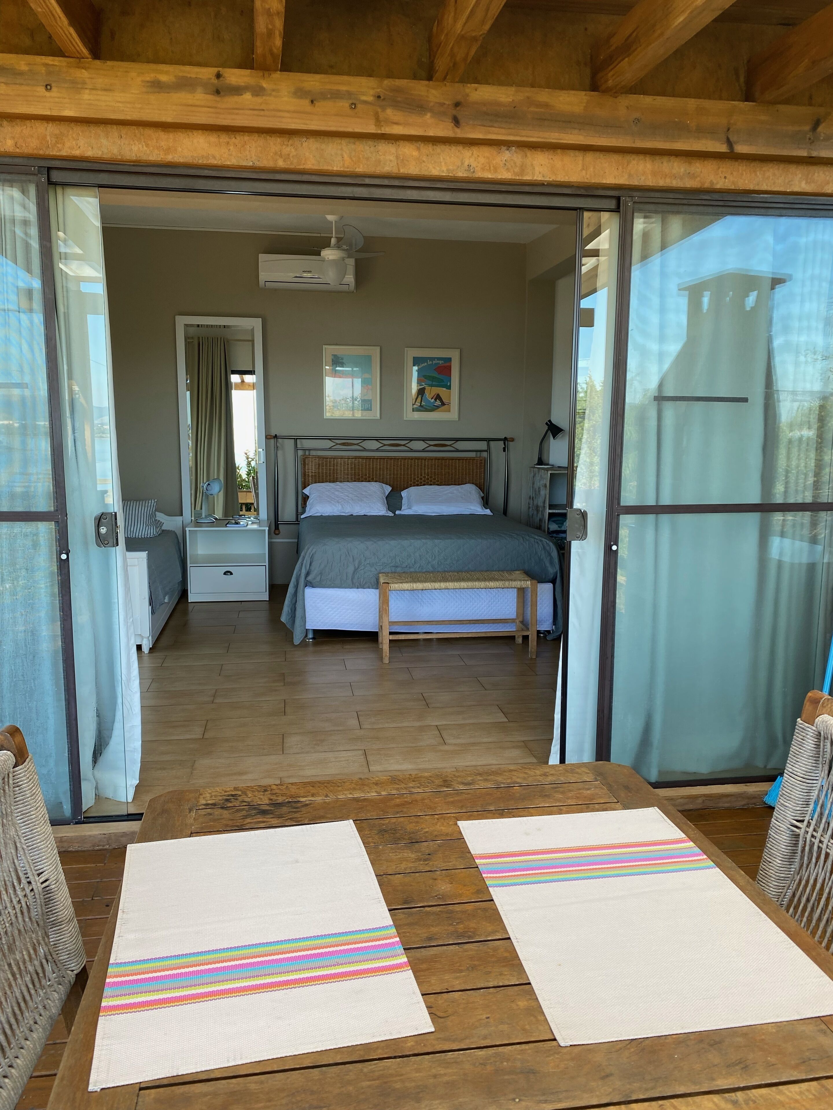 Quarto com cama, mesa de cabeceira e janela.