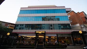 Um hotel com fachada moderna, entrada visível e placa indicando ser o Hotel Albanopolis.