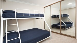 Quarto com beliche, espelho e piso coberto por carpete.