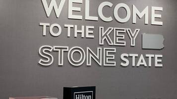 Paredes com a inscrição 'WELCOME TO THE KEY STONE STATE' e um sinal de Hilton Honors.
