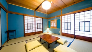 Um quarto japonês tradicional com tatames, uma mesa de madeira e biombos shoji.