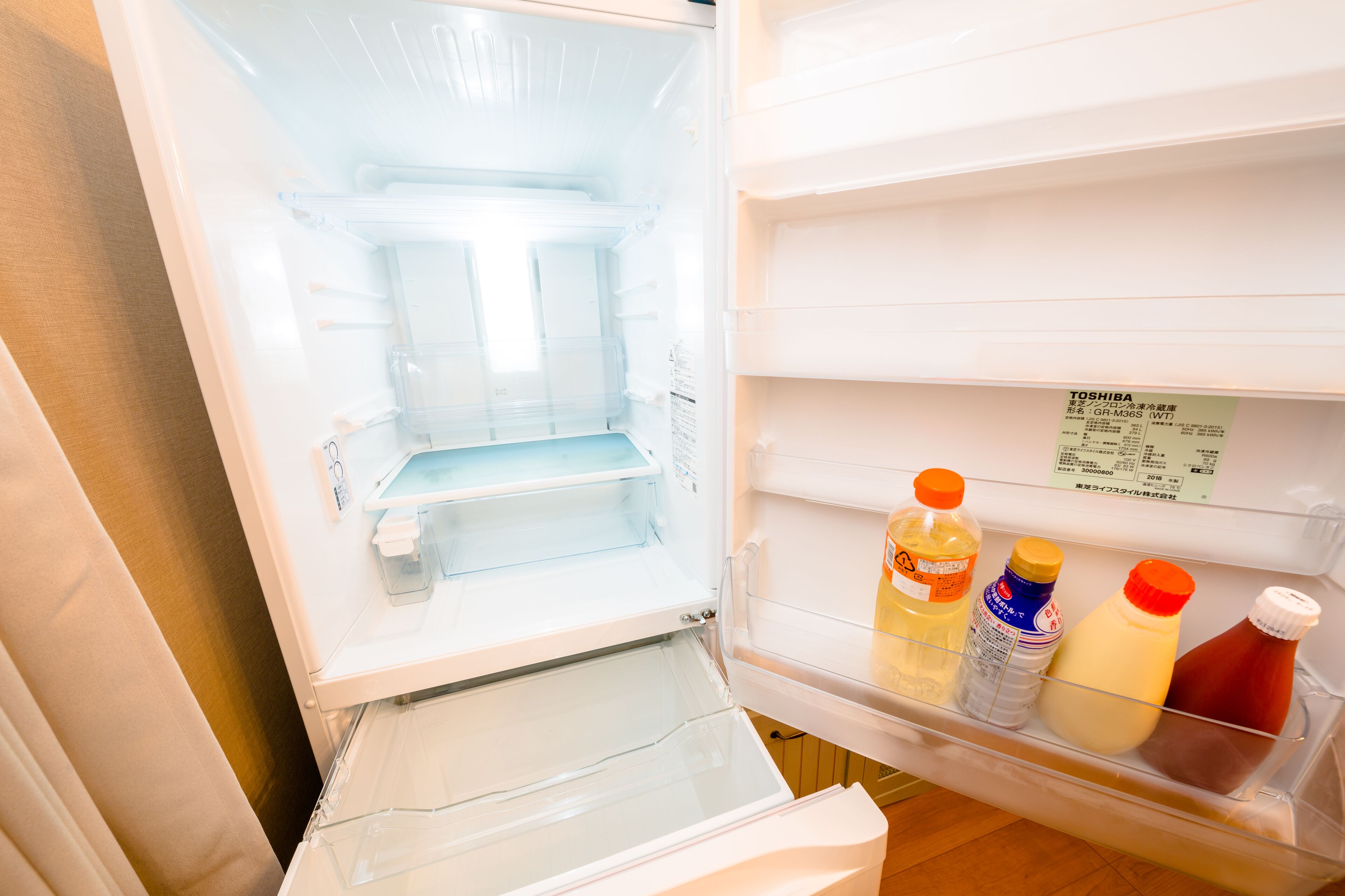 Geladeira aberta com prateleiras e compartimento congelador.