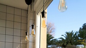 Cozinha com balcão longo, lâmpadas pendentes e vista para o exterior.