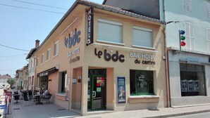 Um hotel com bar e placa indicando 'le bdc bar hotel du centre'.