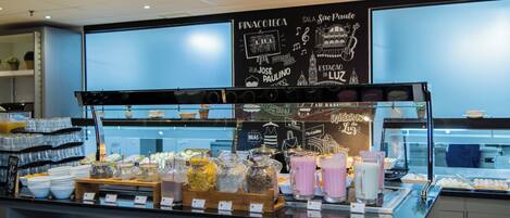 Um buffet de café da manhã com diversos alimentos e bebidas.