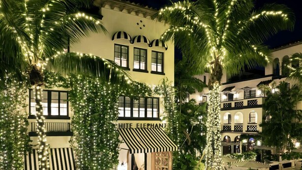 Um hotel com fachada branca, várias varandas e uma placa com a inscrição 'WHITE ELEPHANT'.