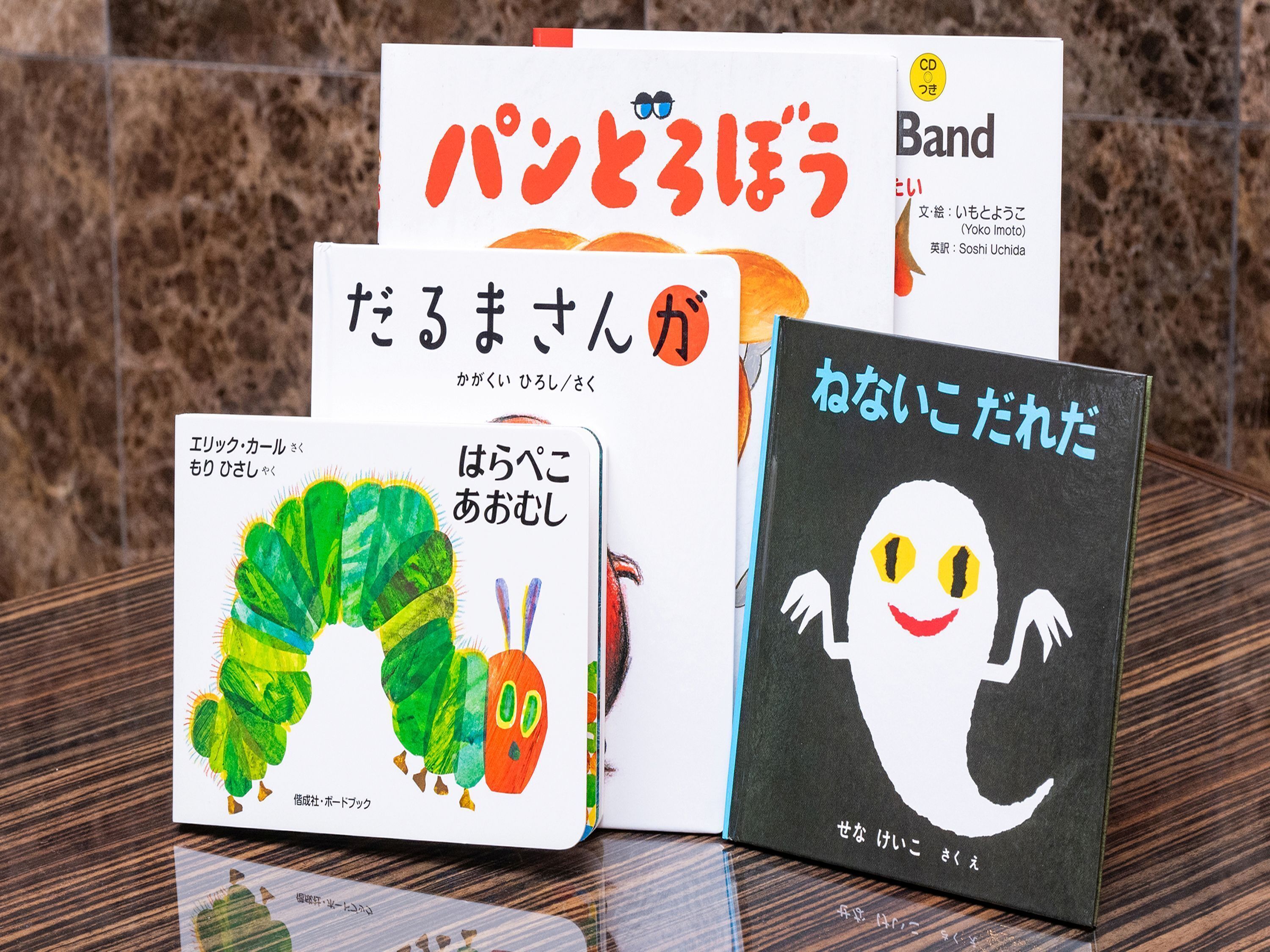 Uma coleção de livros com texto em japonês, colocada sobre uma superfície de madeira.