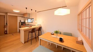 Uma cozinha compacta com uma ilha central, banquetas e iluminação pendente.