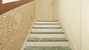 Escadaria com degraus de mármore verde e parede com manchas.