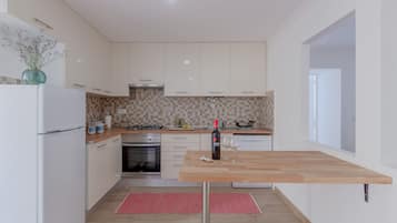 Apartamento, 3 quartos | Cozinha privada | Geladeira grande, fogão, cooktop, lava-louças