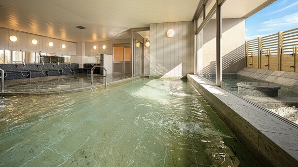 Uma piscina interior ampla com várias pistas de natação, área de vestiários e seção de sauna.