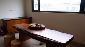 Uma mesa de madeira com design de borda diferenciado, uma pia e uma janela com vista para edifícios.