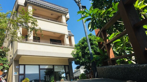 Um edifício de vários andares com telhado plano, janelas amplas e uma varanda.
