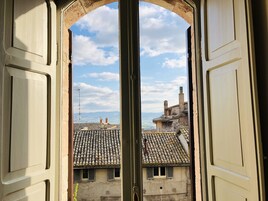 Uma porta aberta mostrando vista de edifícios tradicionais com telhados de azulejos e céu claro.