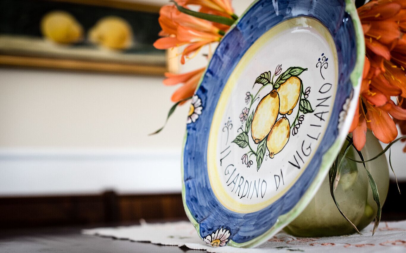 Um prato de cerâmica com um desenho floral e o texto 'Il Giardino Di Vigliano'.