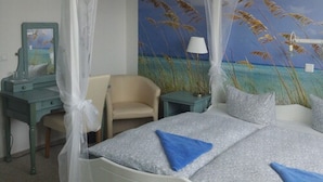 Quarto com cama, cadeira, escrivaninha e mesa de cabeceira.