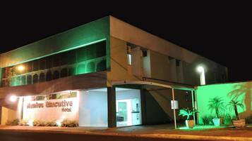 Um hotel com design moderno, apresentando uma entrada imponente e uma placa com a inscrição "Mantas Executive Hotel".