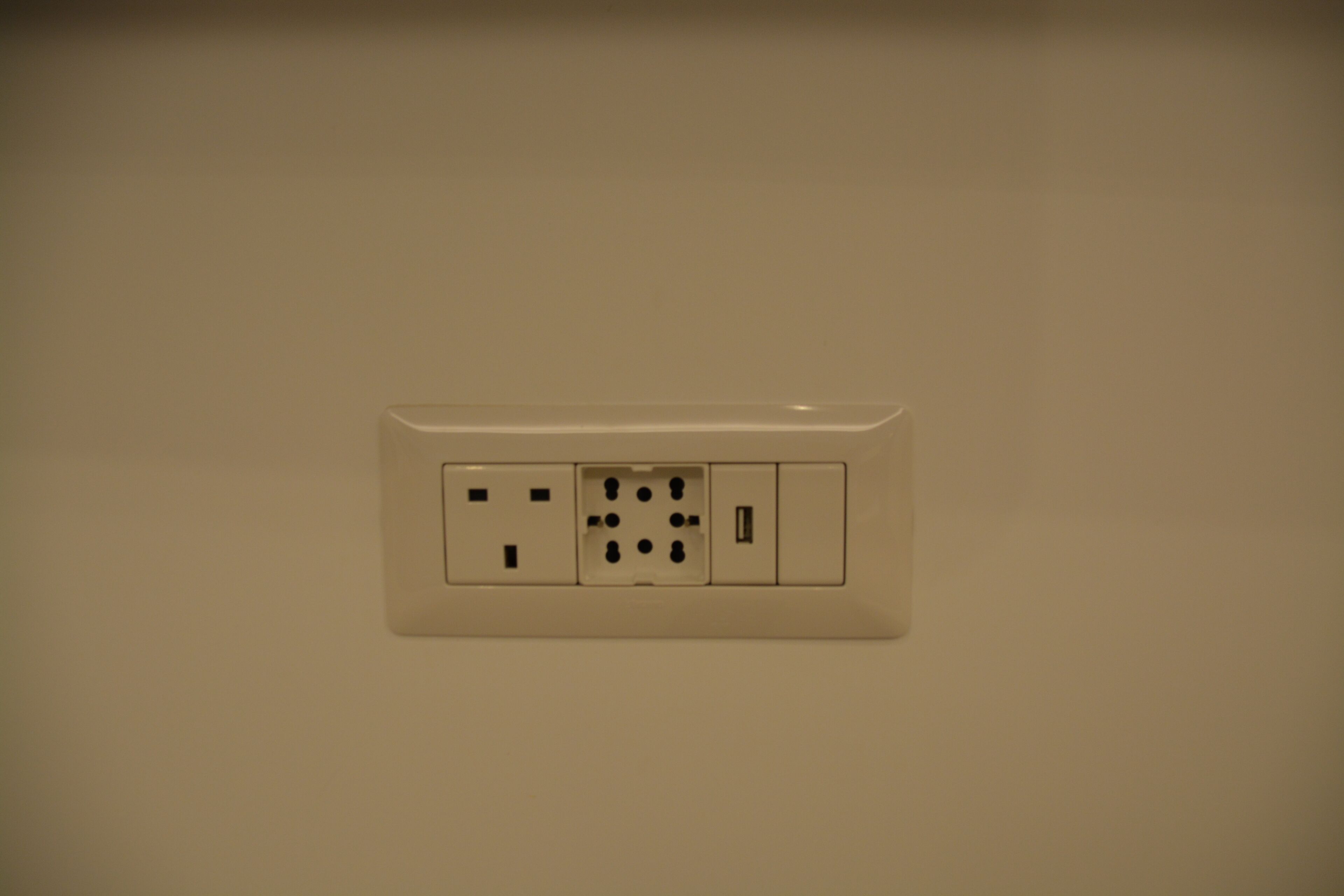 Tomada elétrica na parede com várias entradas e porta USB.